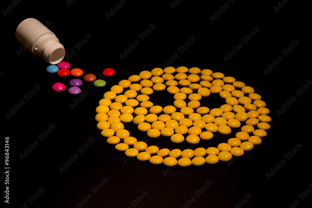 Yellow smiley emoticon made from candy, danger of drugs, drugs looking ...