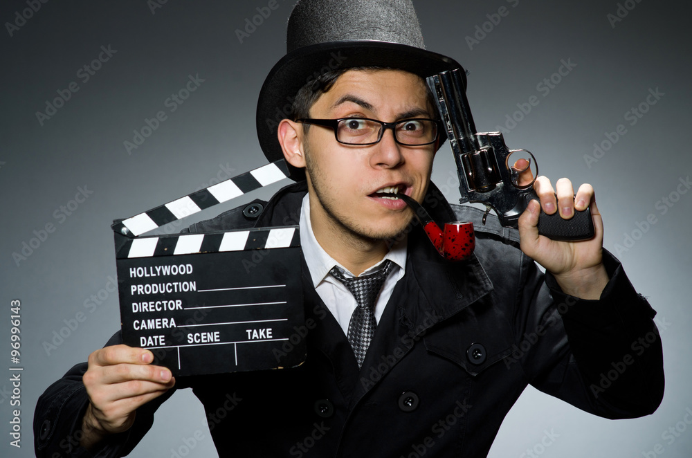Detective in black coat with clapperboard against gray Stock Photo ...