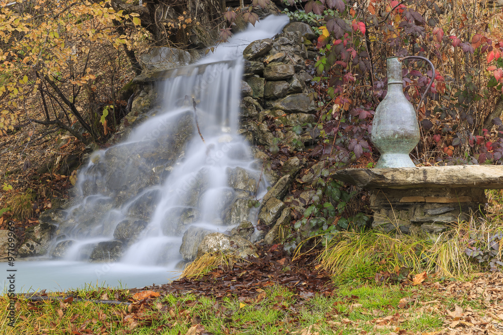 Waterfall and the ancient vessel for water transfer.Village Vand Stock ...