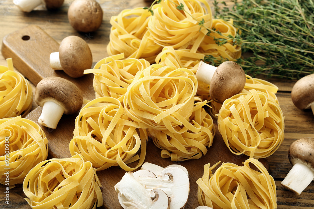 pasta italiana grezza tagliolini all'uovo con funghi freschi Stock ...