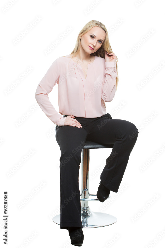 Elegant beautiful woman sitting on a contemporary metal bar stool ...