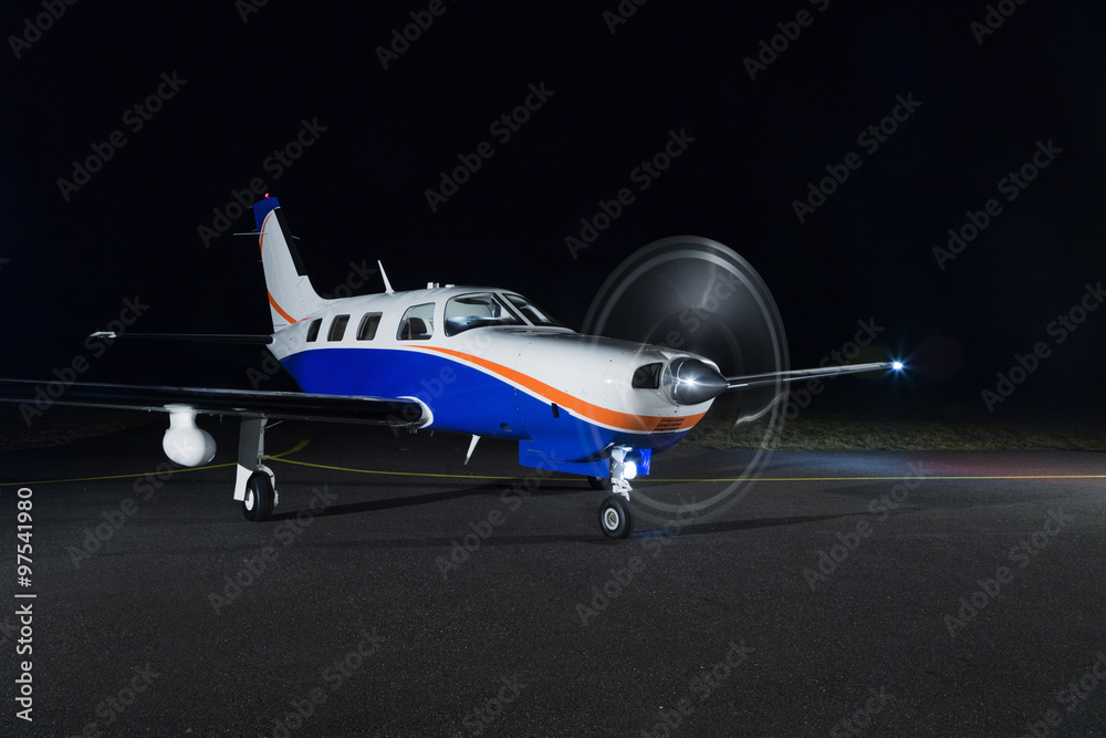 The small single-engine piston aircraft on the runway, illuminated with ...