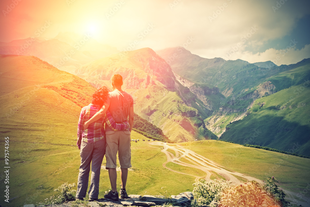 Rear view, couple hikers looking into the distance, is standing on the ...