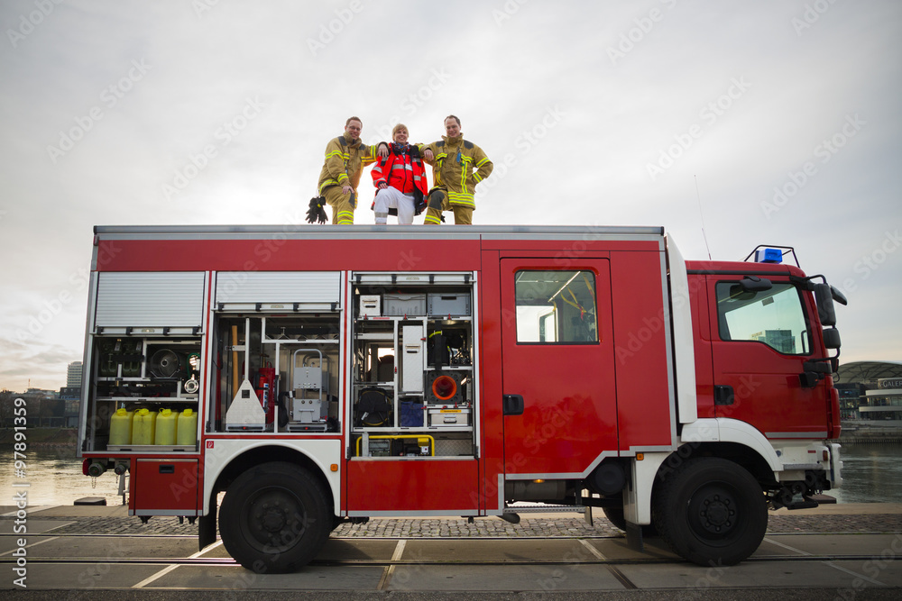 Firefighters and paramedic at the top of the fire engine truck Stock ...