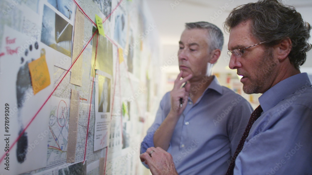 Police detectives working together in incident room to try and solve a ...