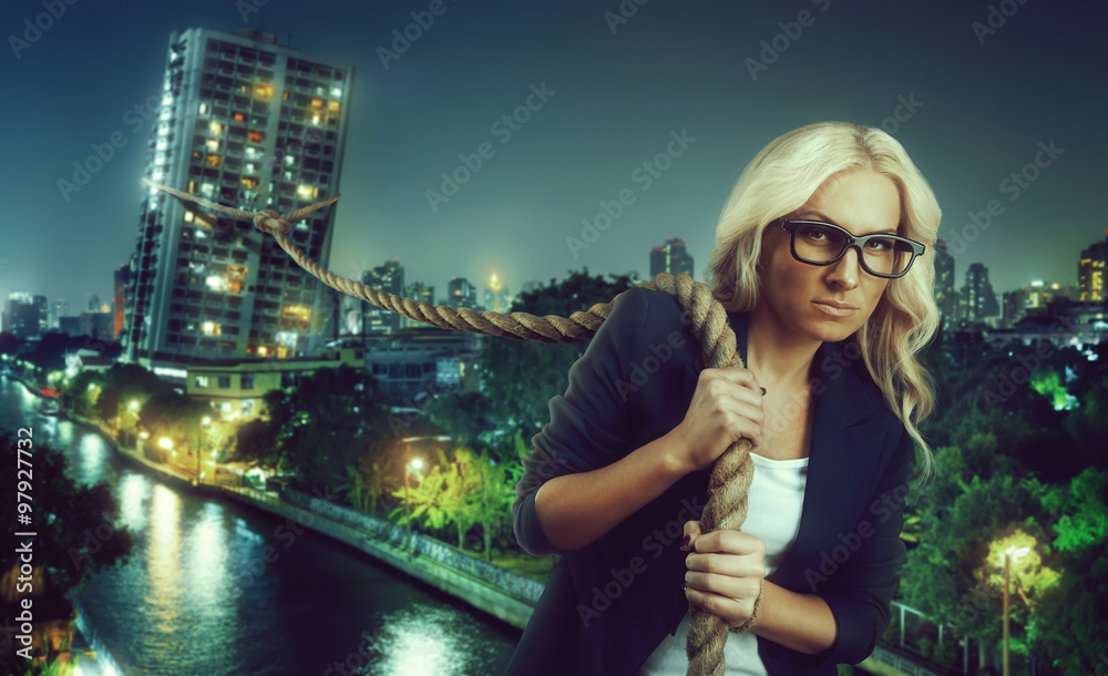 Woman pulling a big building with rope Stock Photo | Adobe Stock