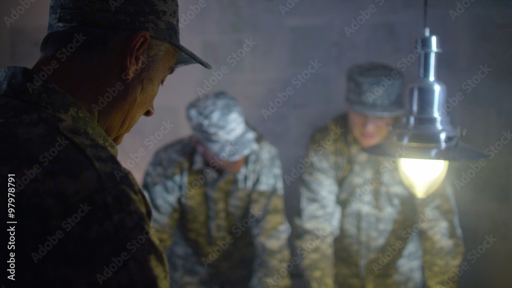 Military officers in army bunker, looking at map & discussing battle ... Military officers in army bunker, looking at map & discussing battle ...