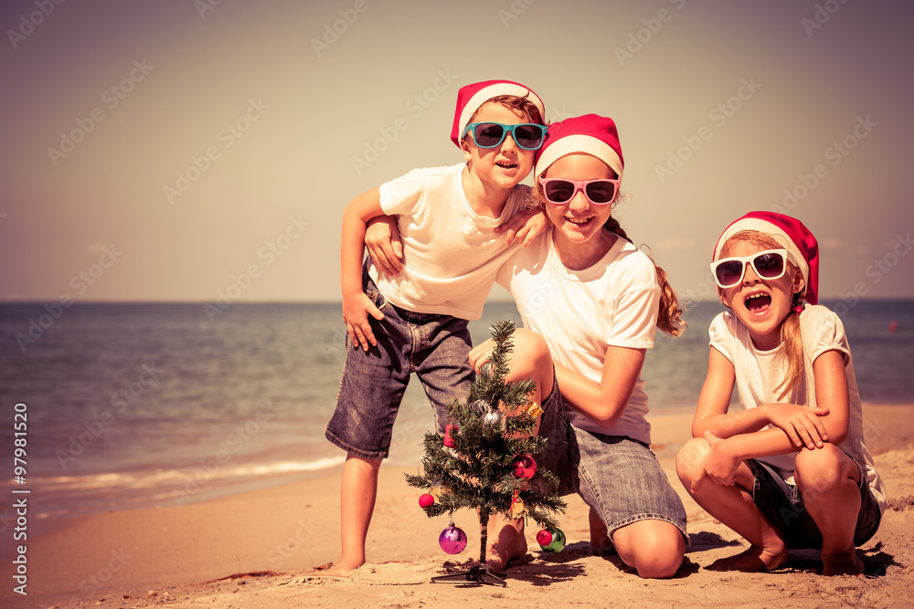 Three happy children playing on the beach at the day time. Stock Photo ...