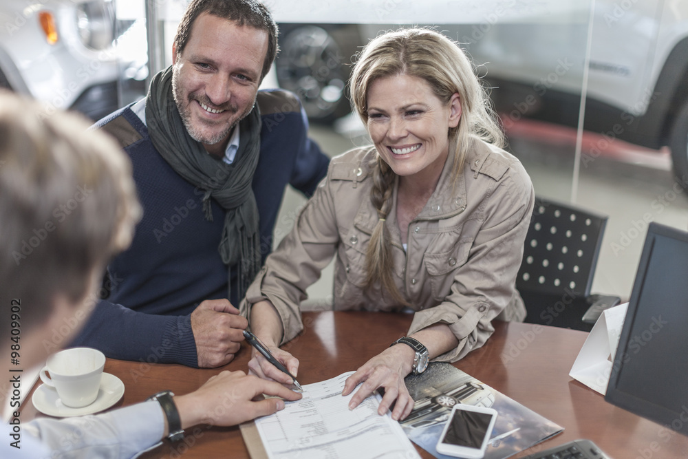 Couple signing sales contract at car dealership Stock-Foto | Adobe Stock