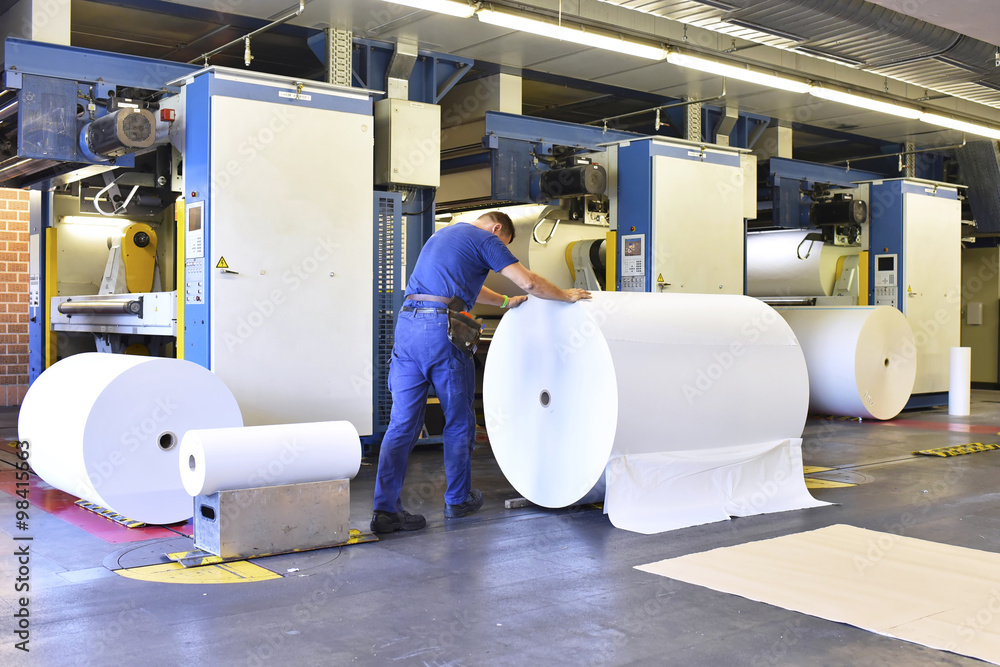 Man moving paper roll in a printing shop Stock Photo | Adobe Stock