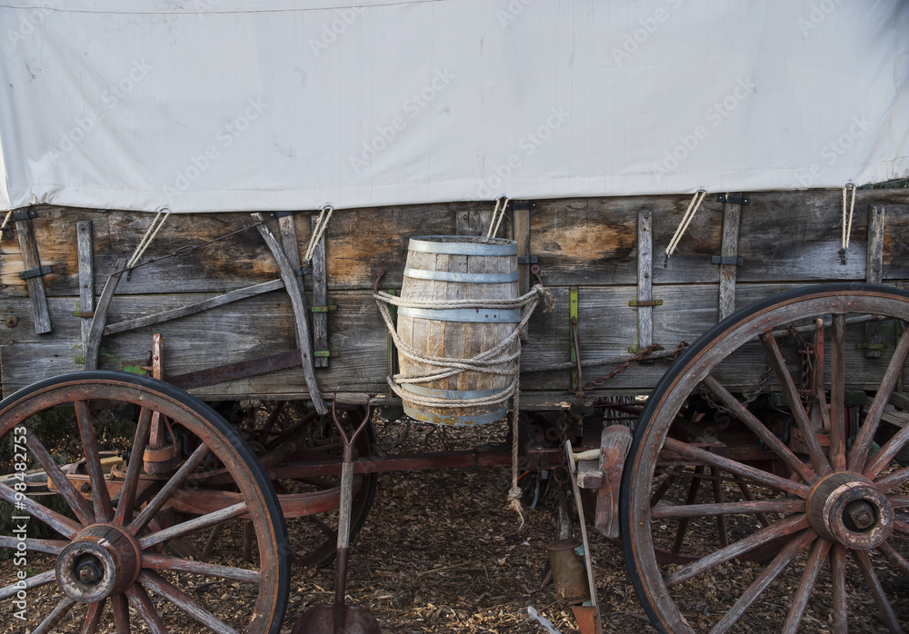 Side view of pioneer wagon with water barrel and canvas top Stock Photo ...