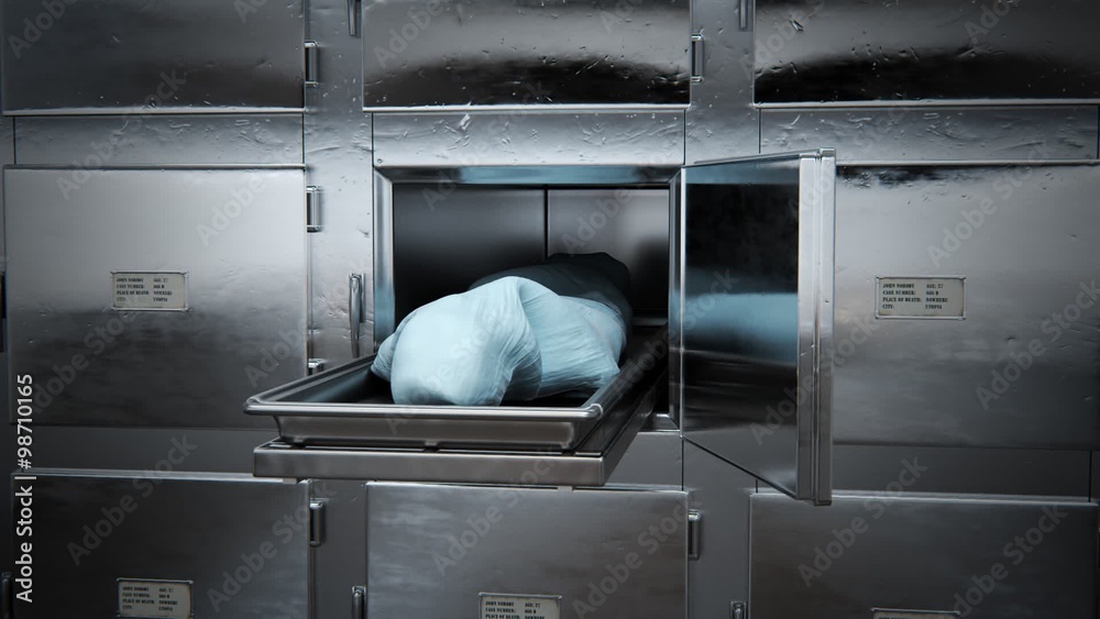 Close up on the opened locker in the morgue. A dead body covered with ...