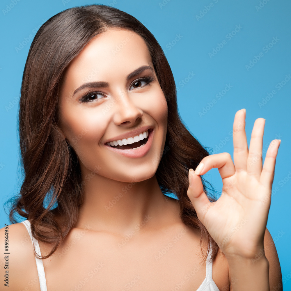 Woman showing okay or zero hand gesture, on blue Stock Photo | Adobe Stock
