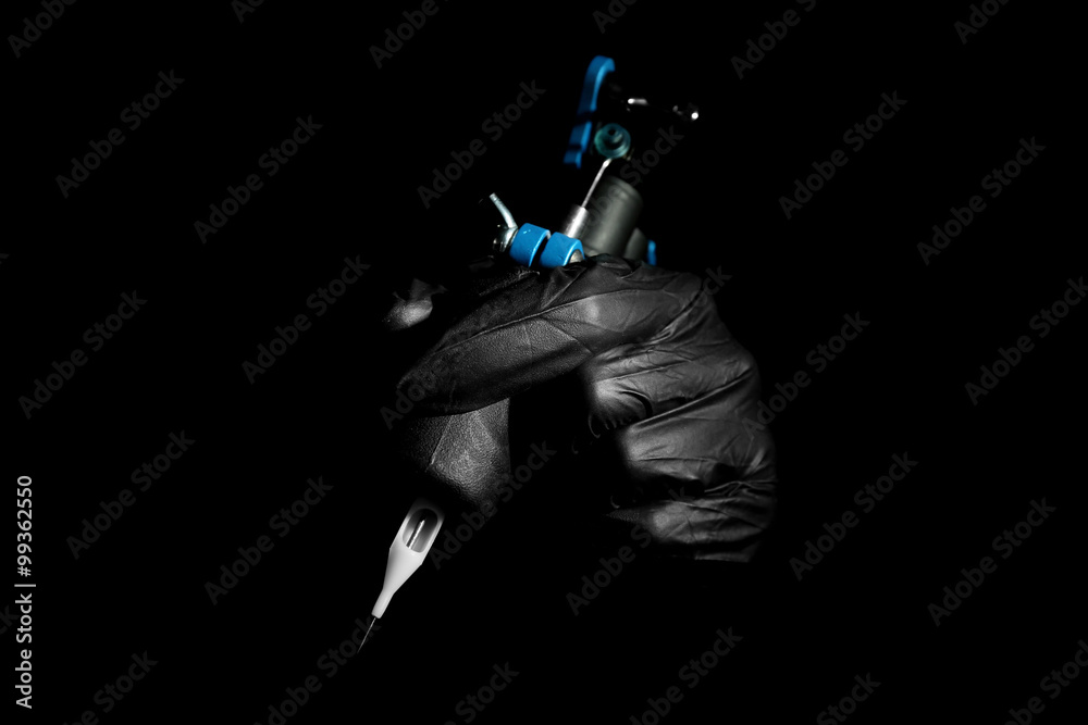 Tattoo artist holding tattoo machine on black background Stock Photo ...