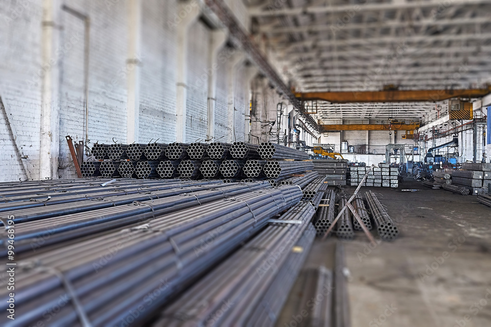 Metal pipes in a warehouse. Stacks of new round steel pipe in fa Stock ...