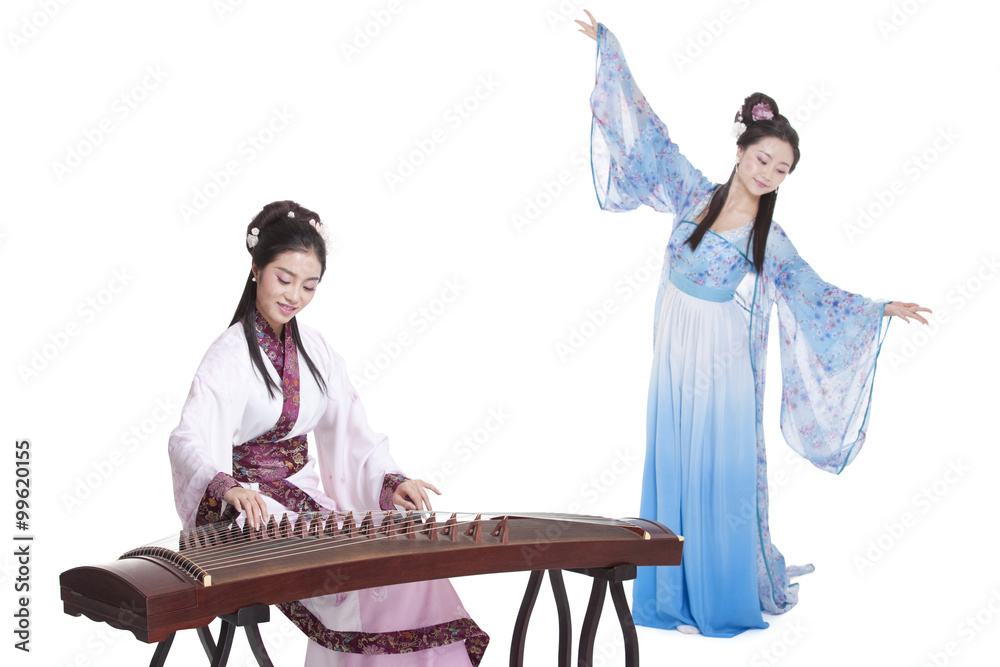 Young women in Chinese traditional costume plucking Chinese zither and ...