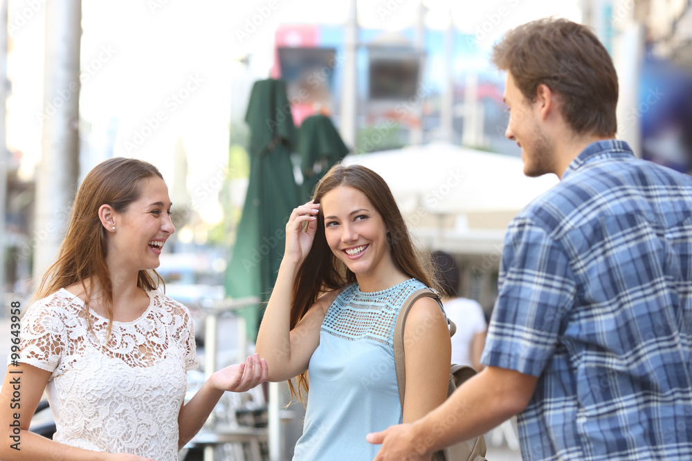 Foto de Girl with a friend flirting with a boy do Stock | Adobe Stock