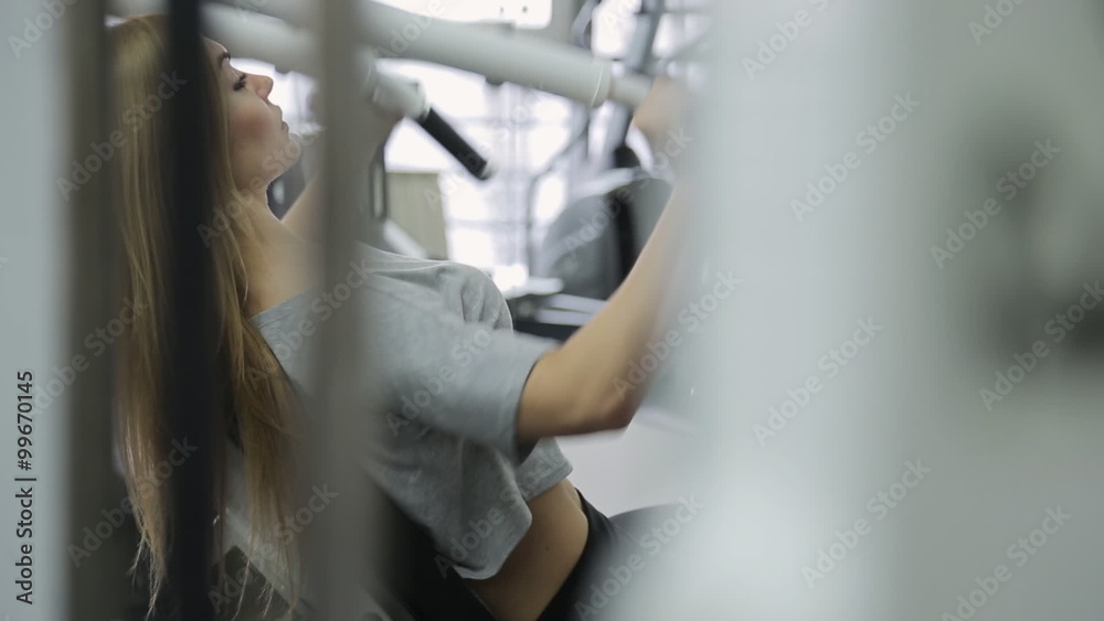 athlete woman with muscular body doing exercise on the chest and biceps ...
