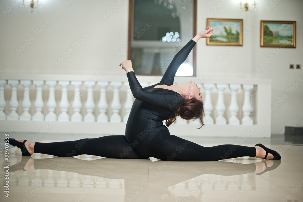 Graceful ballerina doing the splits on the marble floor. Gorgeous ballet dancer performing a ...