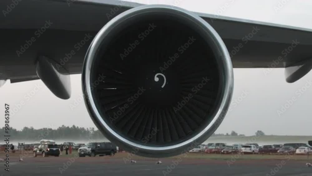 Tilt up from ground to a Boeing 747 jet engine, just before sunrise ...