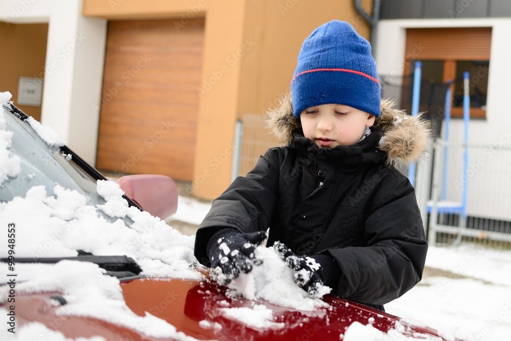 Boy playing with snow outside Stock Photo | Adobe Stock
