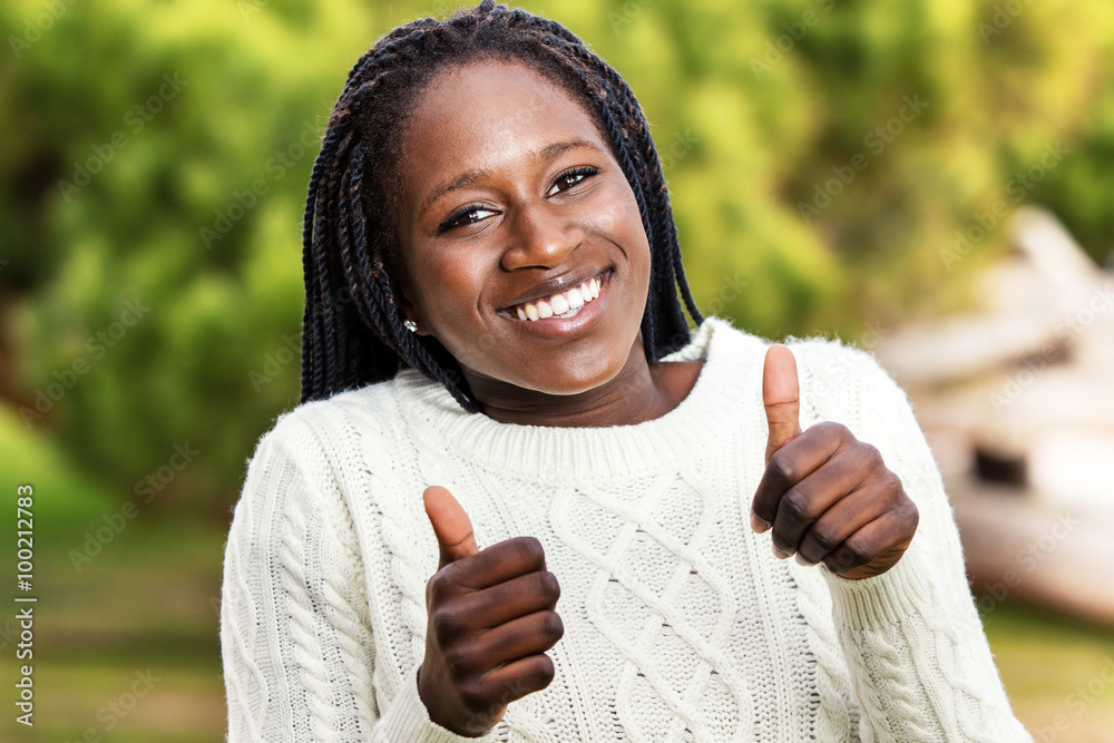 African teen doing thumbs up outdoors. 스톡 사진 | Adobe Stock