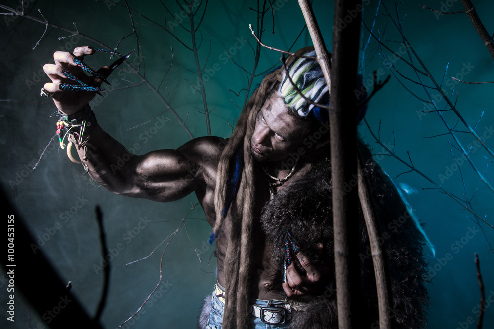 Muscular werewolf with dreadlocks with long nails among the bran Stock ...