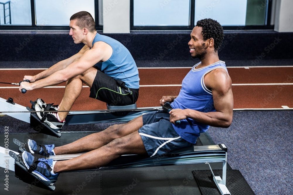 Muscular men using rowing machine Stock Photo | Adobe Stock
