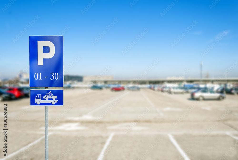 Parking lot with number of authorized parking sign with tow truck on ...