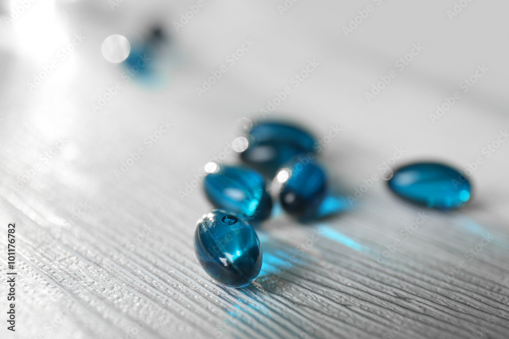 Transparent blue pills on a grey table, close up Stock Photo | Adobe Stock
