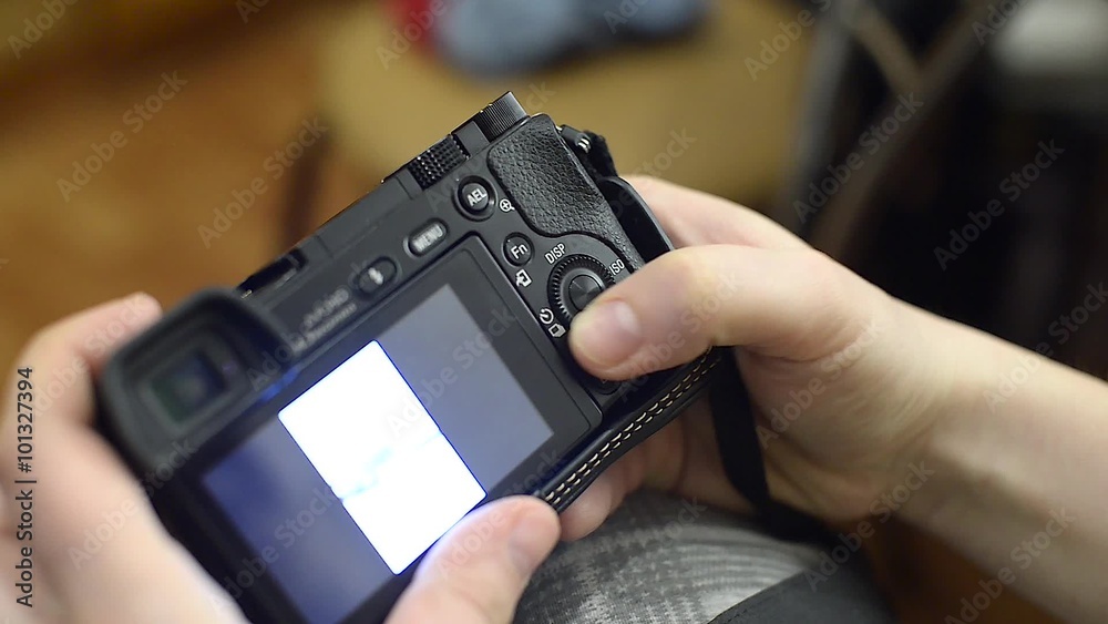 She sets up the camera before shooting. Man turns the wheels of the ...