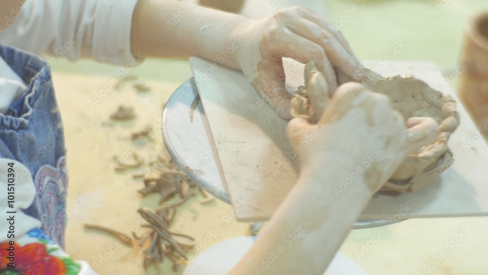 Little Girl is Trying to Make a Clay Pot Putting a Pieces of Clay ...