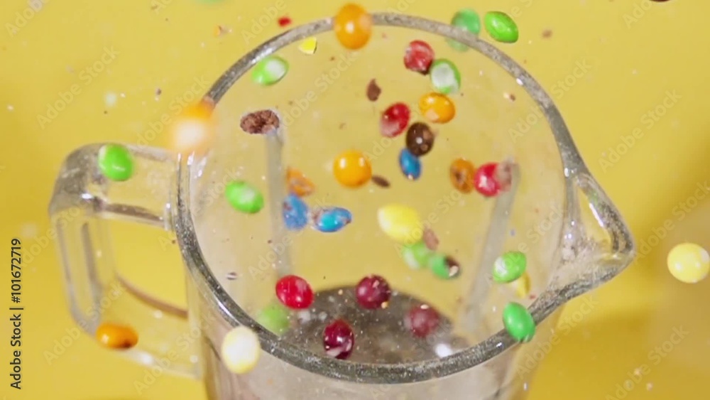 Candy explosion on yellow studio background in blender in slow motion ...
