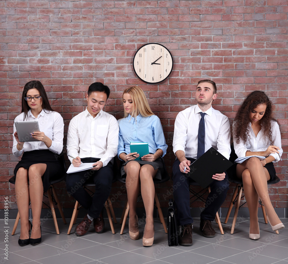 Young people sitting on a chairs in brick wall hall Stock Photo | Adobe ...