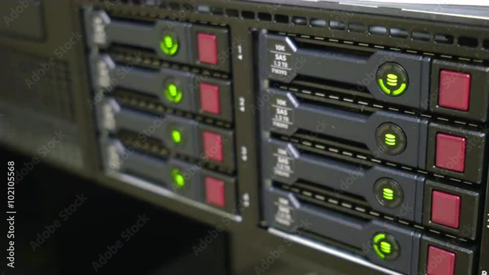 Close up of green LED lights on multiple hard drives of a large server ...