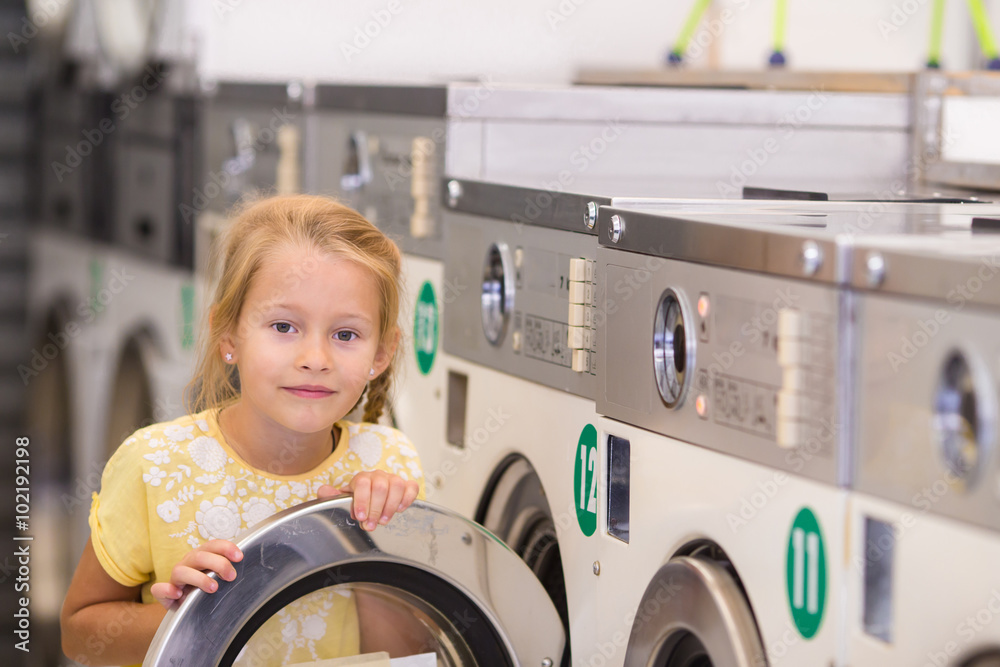 Adorable little girl in laundry room Stock Photo | Adobe Stock