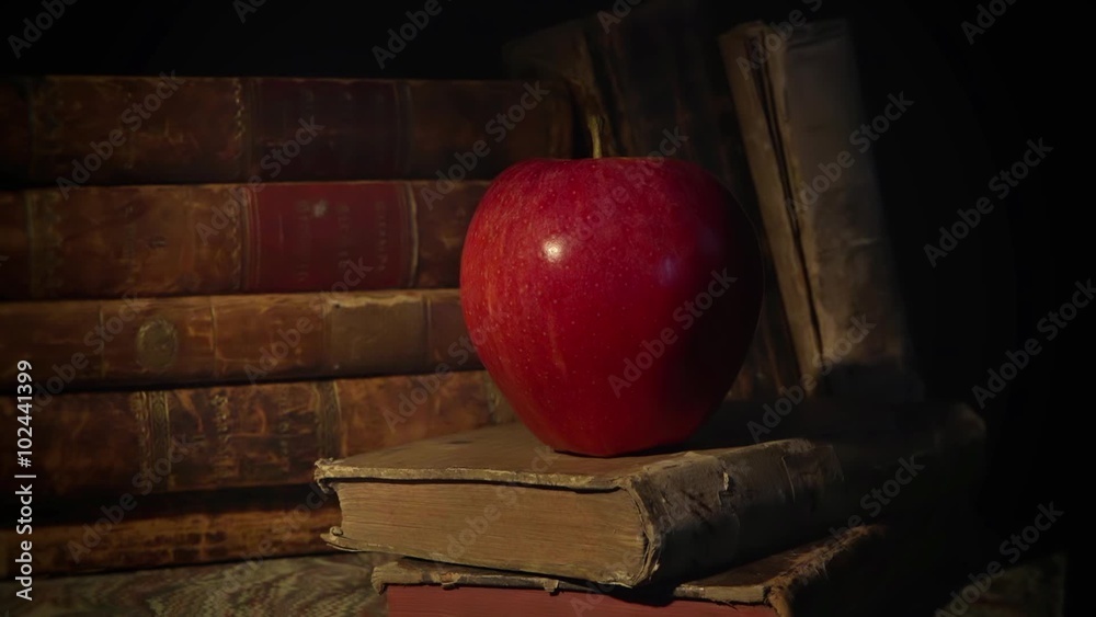 Stockvideon Apple of knowledge. Old aged and worn books in a stack with ...