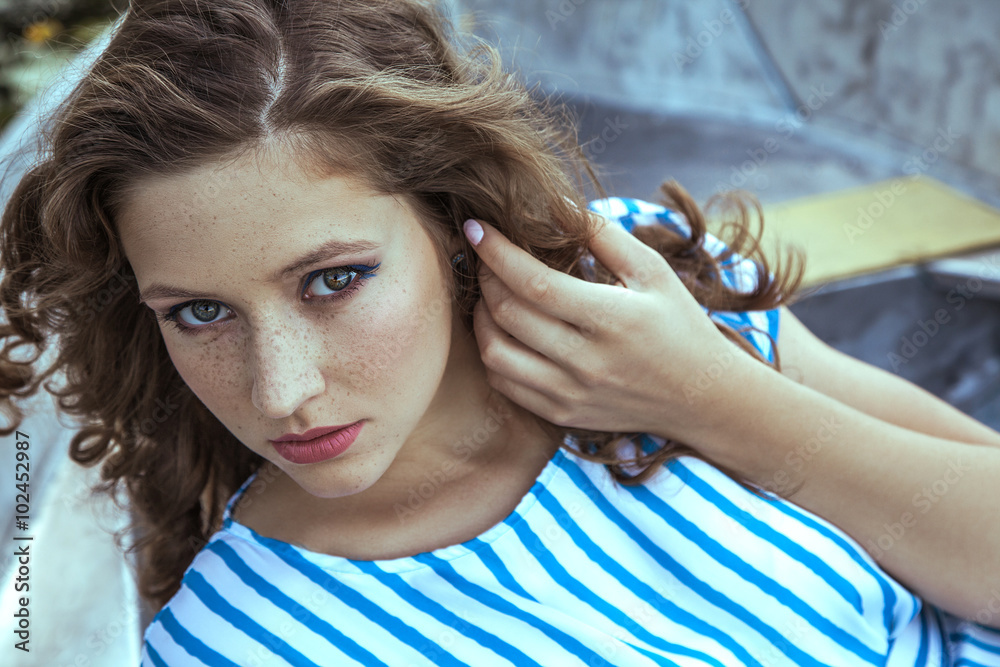 Beautiful young fashion model with freckles on her face and light blue ...