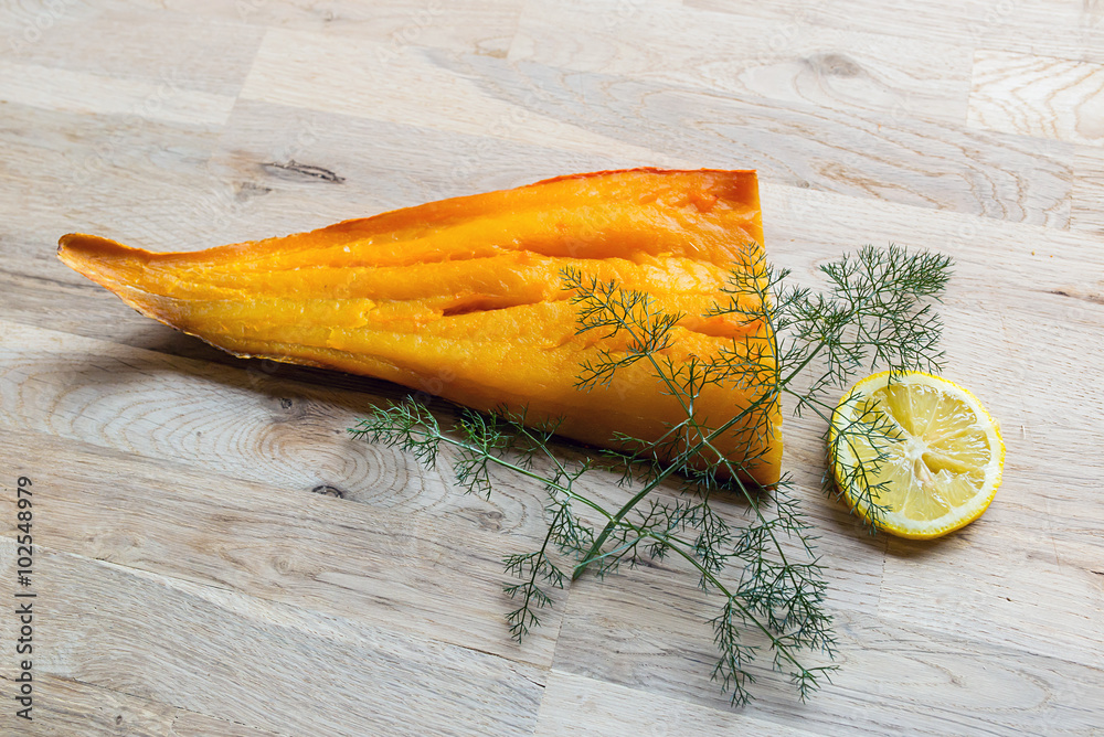 beautiful yellow smoked haddock fish fillet on a natural oak tree table ...