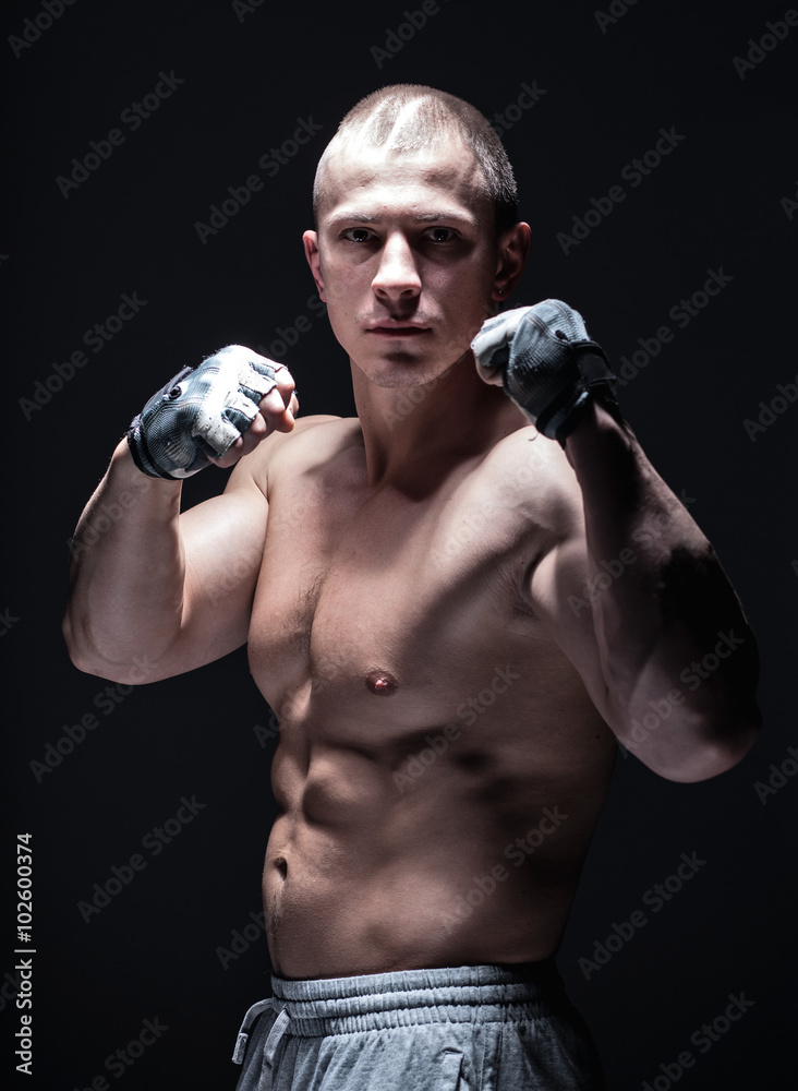 brutal muscular guy in fighting stance in dark space Stock Photo ...