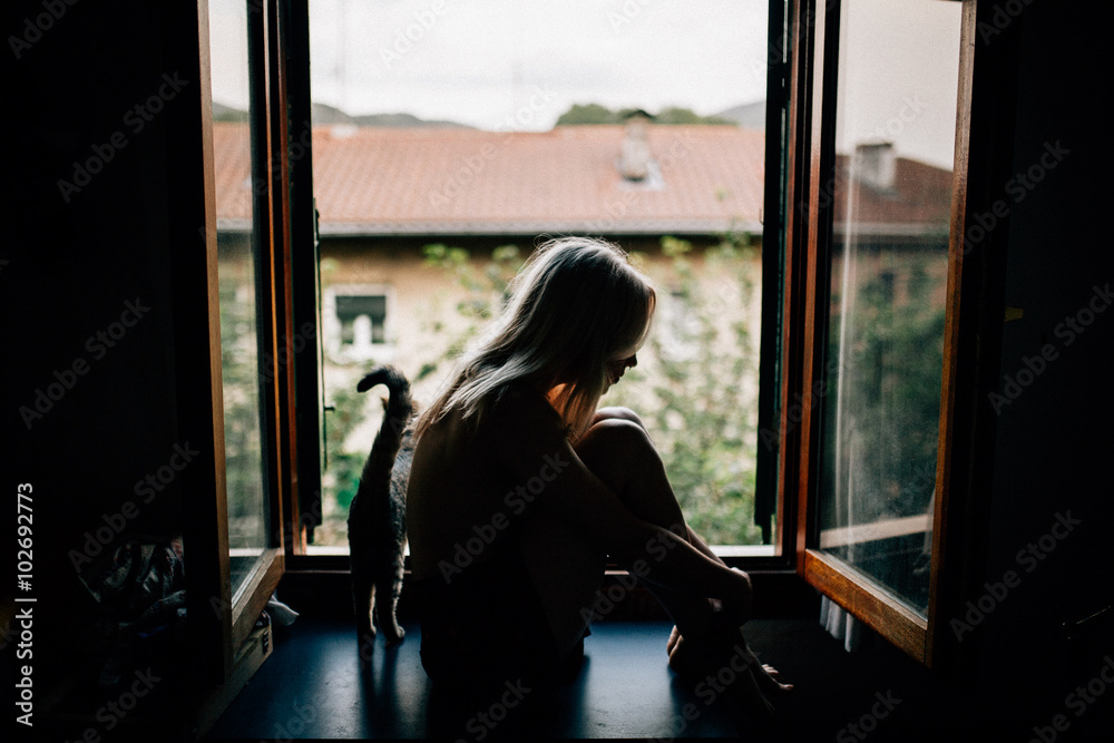 Woman Sitting of a Window Ledge Stock-Foto | Adobe Stock