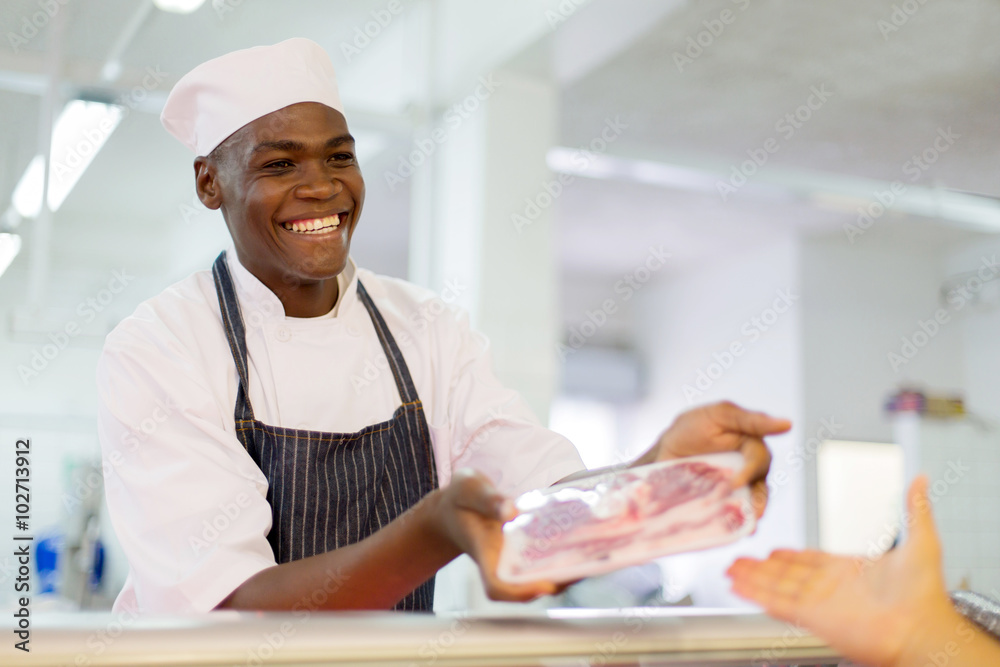 Foto de african butcher selling beef to customer do Stock | Adobe Stock