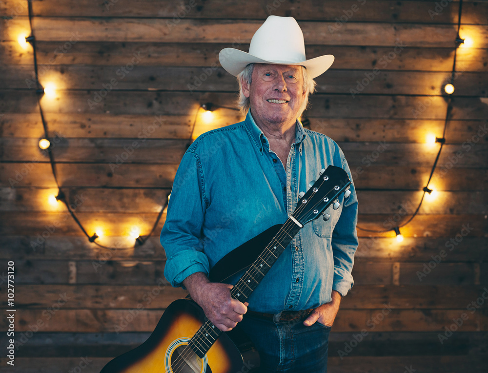 Happy senior country and western musician standing with guitar. Stock ...