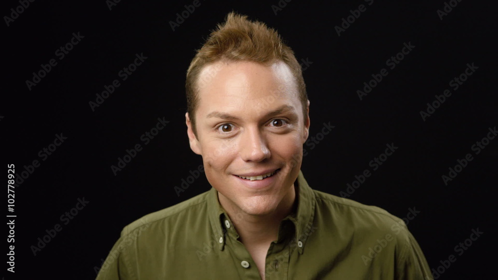 Surprised young adult man looking at camera and smiling. Black ...