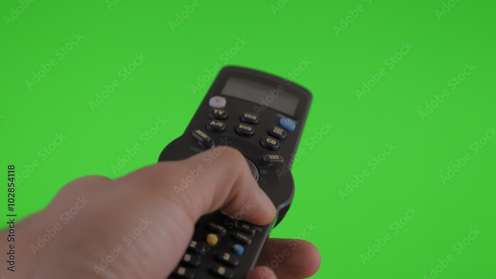Changing channels with remote control in hand on green screen chroma ...