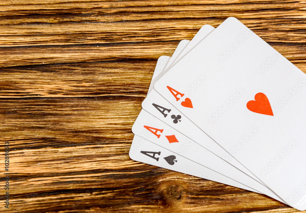 Four aces on wooden background Stock Photo | Adobe Stock