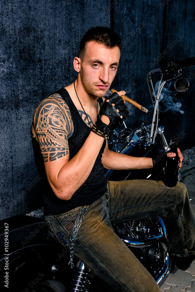 Bad boy sitting on his motorcycle and smoking a cigar Stock Photo ...
