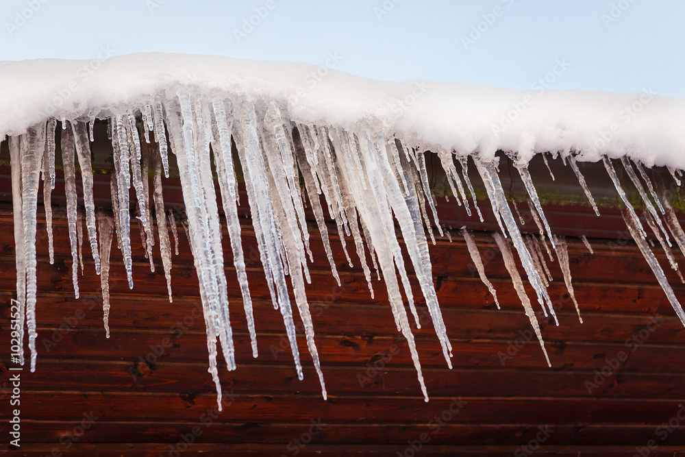 Icicles on the roof. Winter concept. Wood and sky background. Stock ...