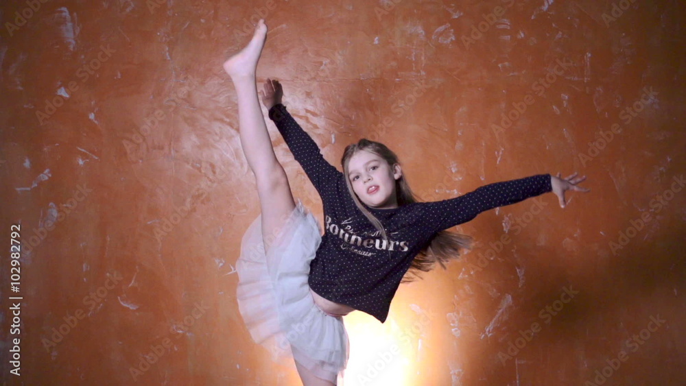 Flexible little girl doing vertical split in studio. Girl gymnast doing ...