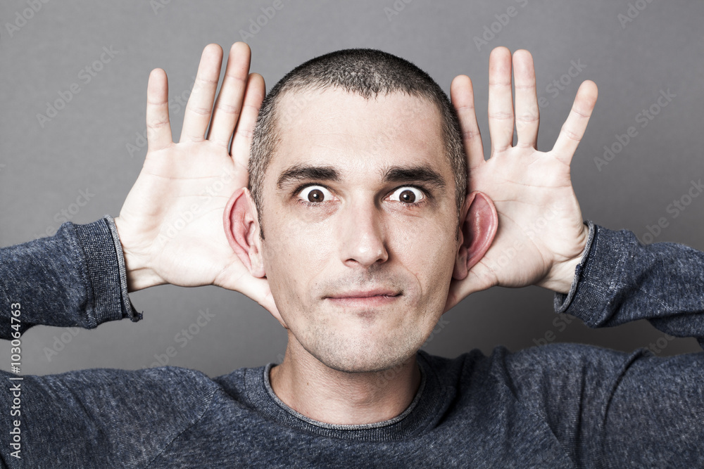 curiosity and hearing concept - playful young man emphasizing the size ...